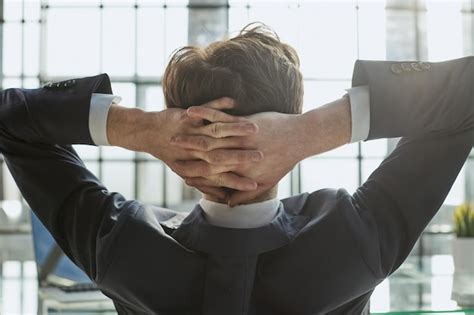 Trabajador Sentado En La Oficina Con Las Manos Detrás De La Cabeza