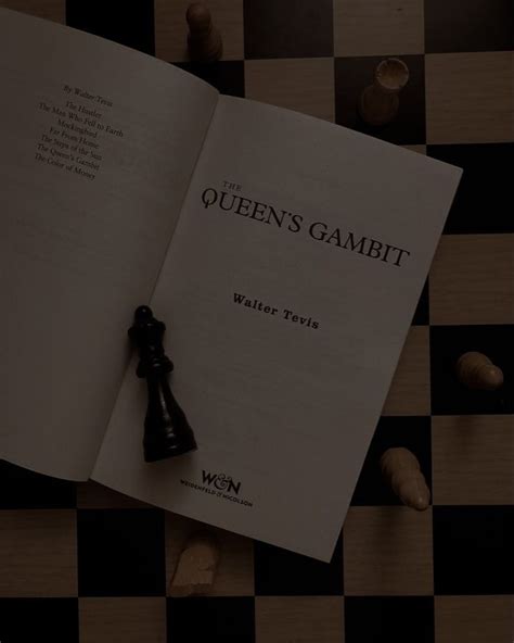 The Queens Gambit Book Is Open On A Chess Board