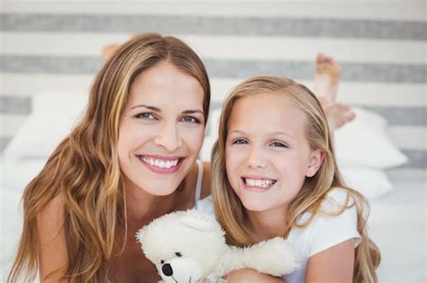 Premium Photo Smiling Mother And Her Daughter On Bed At Home