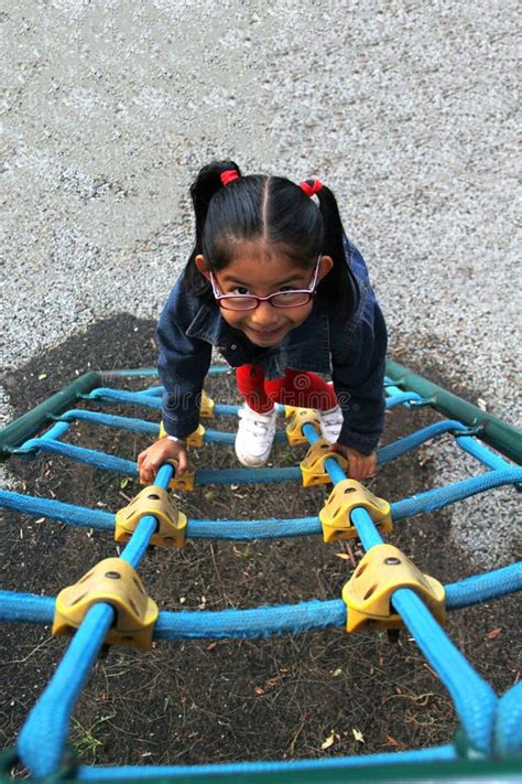 4 Year Old Latin Brunette Girl With Eye Glasses Plays In The Playground