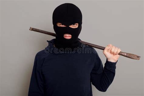Un Ladrón De Ladrones Con La Cara Disimulada Sostiene Una Cartera