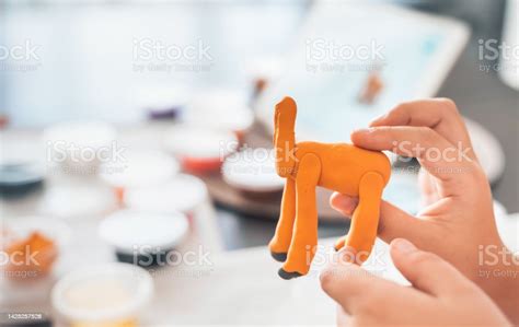 어린 소녀들은 공기 Plasticine에서 인형 공예품을 조각하여 반죽을 모델링합니다 태블릿에서 온라인 레슨 아이들의 창의력