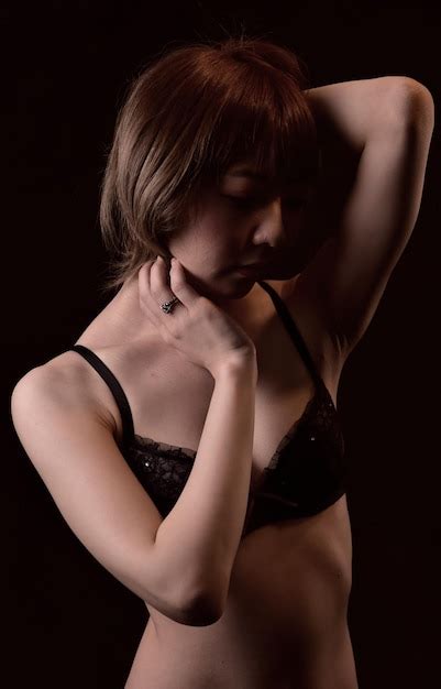 Premium Photo Midsection Of Shirtless Woman Against Black Background