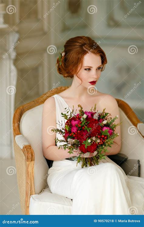 Very Pretty Sophisticated Red Haired Girl Sitting In A Chair Wit Stock