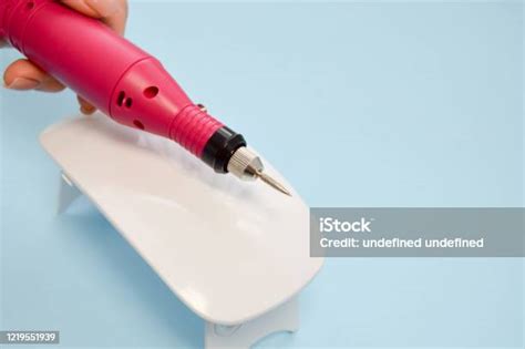 파란색 배경에 네일 뷰티 살롱에서 니스를 건조하기위한 특별한 기계와 램프의 도움으로 손가락에 손에 아름다운 매니큐어를 만드는 과정 고객에 대한 스톡 사진 및 기타 이미지