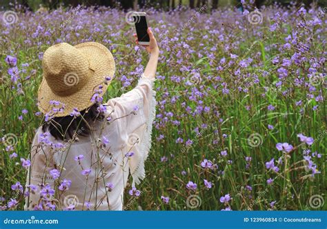 Young Female Taking Selfie Picture In The Flower Field With Her Mobile