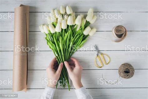 나무 테이블에 팩 공예 종이에 흰색 튤립의 아름다운 꽃다발을 포장 하는 여자 꽃집 플랫 레이 공예에 대한 스톡 사진 및 기타