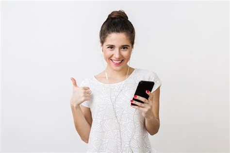 Mujer bonita joven con estilo sonriendo en camiseta escuchando música en auriculares
