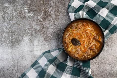 Shchi 어두운 배경의 그릇에 쇠고기와 소금에 절인 양배추를 곁들인 전통적인 러시아 양배추 수프 상단보기 평평한 누워 감자