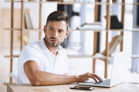 办公室工作单位在笔记本电脑上工作时向远处看的高清图片下载 正版图片502572618 摄图网