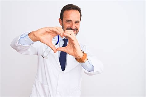 외투와 청진기를 입은 중년 의사 남자가 고립된 흰색 배경 위에 서서 손으로 심장 기호 모양을하고 사랑에 미소 로맨틱 한 개념 개념에 대한 스톡 사진 및 기타 이미지 Istock