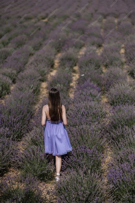 Una Chica Con Un Vestido Morado Y Un Sombrero Grande Posa En Un Campo