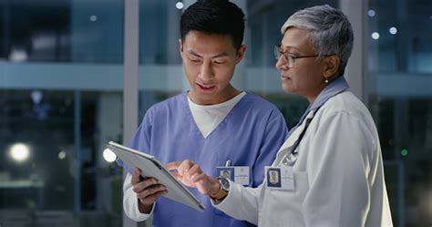 태블릿 의료 연구 및 의사는 임상 결과를 위해 야간 근무를 할 때 병원에서 멘토와 함께 합니다 조언 디지털 기술 및 의료 인턴과 함께 외과 의사와 함께 초과 근무로 온라인