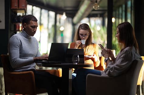 퇴근 후 또는 식당에서 커피를 마시며 회의를 하는 세 명의 다민족 비즈니스 동료 카페 바에서 일하는 친구들 20 24세에 대한 스톡 사진 및 기타 이미지 Istock