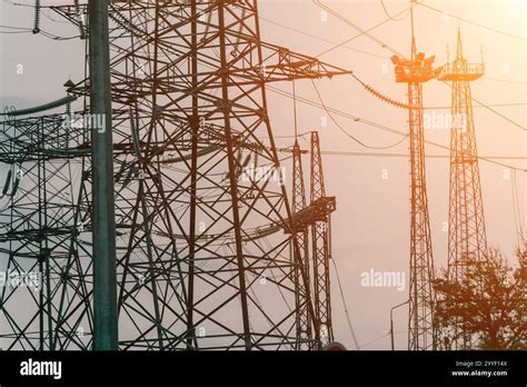 High Voltage Electric Distribution Network At Sunset Power Transmission Lines On Supports With