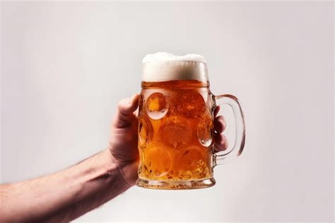 Premium Ai Image Hand Holding A Glass Of Beer On A White Background