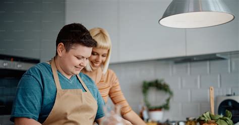 Smiling Lesbian Enjoying In Preparing Food With Her Girlfriend In The