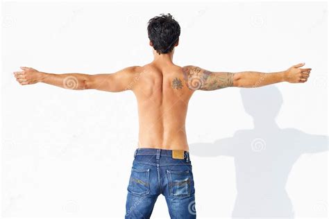 Showing Off His Tattoo A Handsome Man With His Back Towards The Camera