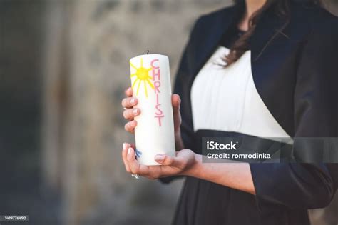 거룩한 확인이나 친교를 위해 십자가에 못 박힌 촛불을 들고 있는 소녀의 손 견진 성사에 대한 스톡 사진 및 기타 이미지 견진