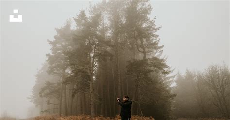 Man In Black Jacket And Black Pants Standing On Brown Grass Field