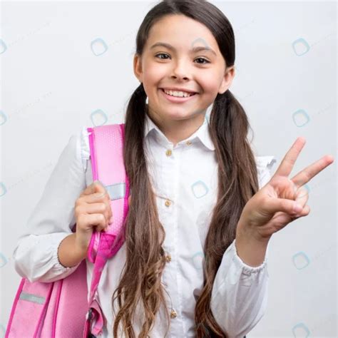 خرید و قیمت تصویر دختر دانش آموز با کیف کولی درحال لبخند زدن به دوربین