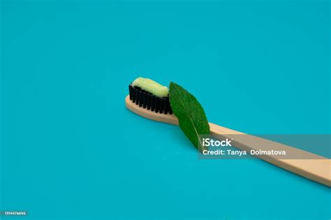 파란색 배경에 녹색 민트 잎 옆에 나무 대나무 칫솔과 치약 0명에 대한 스톡 사진 및 기타 이미지 0명 개성 개념 건강