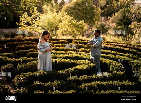 A Happy Pregnant Latina Woman And An African Couple Smiling As They