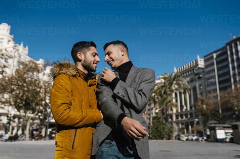 Lächelndes homosexuelles Paar das sich gegenseitig ansieht während es