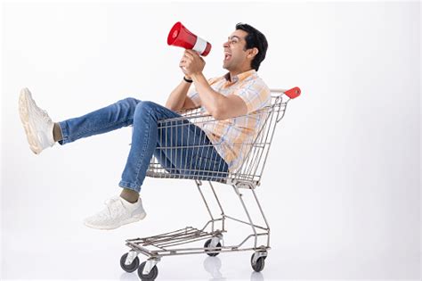 白い背景にショッピングカートの中に座りメガホンを持つ若い男性 カットアウトのストックフォトや画像を多数ご用意 カットアウト