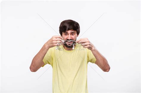 英俊的黑发胡子男因为无法解开他的有线耳机而变得很烦恼该高清图片下载 正版图片504626504 摄图网