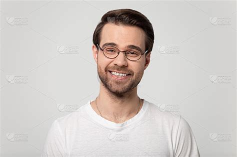 年轻快乐的家伙戴着眼镜看相机肖像。