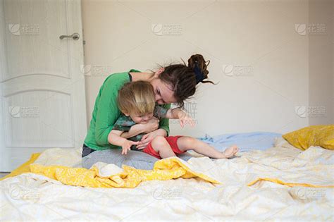 快乐的妈妈和她的儿子在床上放松的早晨