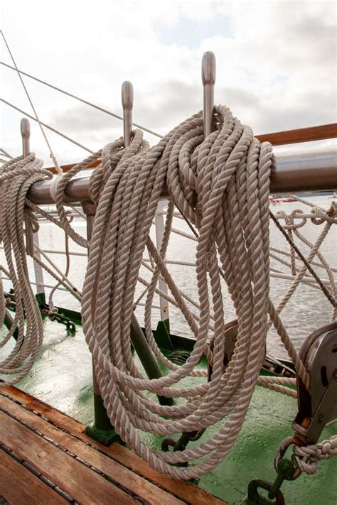 Nautical Ropes Neatly Coiled Around Belaying Pins On A Sailing Ship