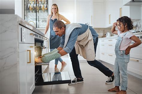 부엌 가족 및 아버지는 어머니와 소녀와 함께 저녁 식사를 위해 식사 점심 및 음식을 준비하기 위해 오븐에서 요리합니다 가족의 집 사랑과 엄마 아빠와 소녀는 축제 축하를 위해