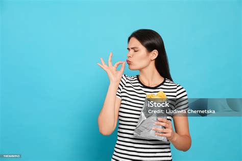 하늘색 배경에 감자칩을 먹는 아름다운 여자 텍스트를 위한 공간 가방에 대한 스톡 사진 및 기타 이미지 가방 먹기 여자 Istock