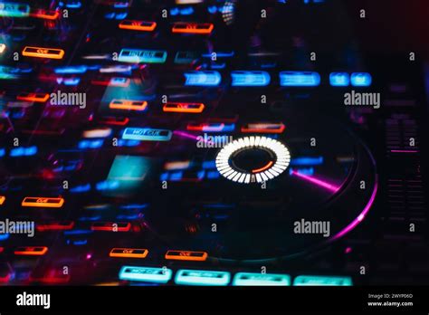 Dj Mixer In A Nightclub With Glowing Colored Lights From Controllers And Buttons In The