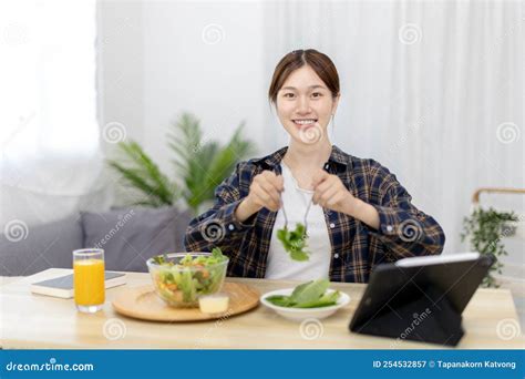 Asian Woman Eating Salad On The Dining Table Smiling And Happy Stock