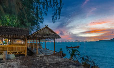 태국 푸켓 섬의 라와이 해변에서 화려한 하늘 일몰 아름다운 청록색 푸른 바다 무성한 녹색 산 다채로운 하늘과 아름다운 전망 부두와 롱테일 보트와 섬 0명에 대한 스톡 사진