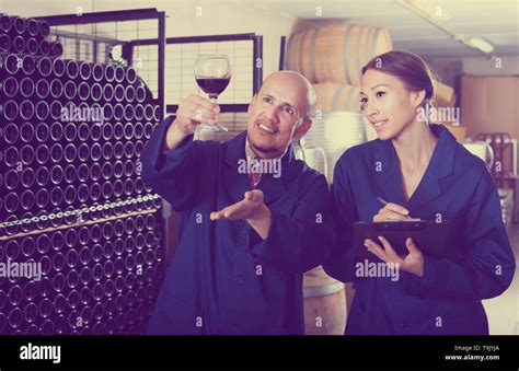 Happy Girl With Cardboard Standing With Male Worker In Small Winery