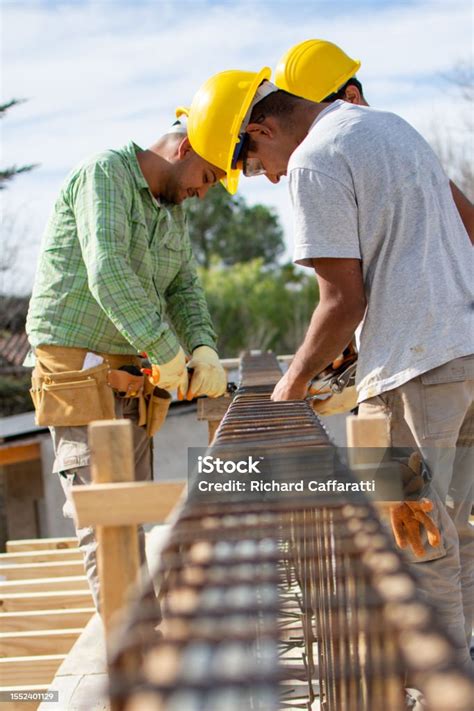 Bricklayers With Yellow Helmet And Protective Glasses Building An Iron