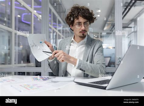 Focused Young Adult Office Worker Examines Important Business Documents