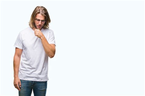 기분이 불쾌 하 고 감기 나 기관지염에 대 한 증상으로 기침 하는 고립 된 배경 위에 안경을 쓰고 긴 머리를 가진 젊은 잘생긴 남자 의료 개념입니다 감기와 독감에 대한 스톡