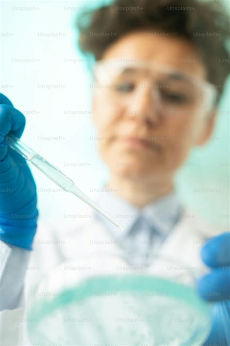 다른 액체를 떨어뜨리면서 액체 물질이 담긴 페트리 접시 위에 플라스틱 피펫을 들고 있는 여성 실험실 작업자의 장갑을 낀 손 사진 Unsplash의 건강 검진 이미지