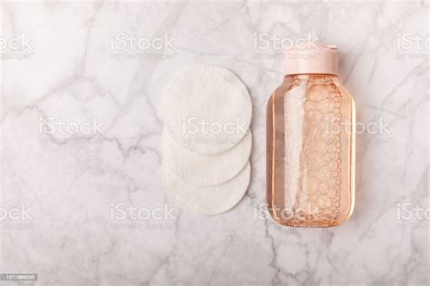 미셀라 워터 화장솜이 있는 메이크업 리무버 강장제 피지와 메이크업으로 피부를 클렌징합니다 흰색 대리석 배경에 구성입니다 아름다움 개념입니다 공간 텍스트를 복사합니다 플랫