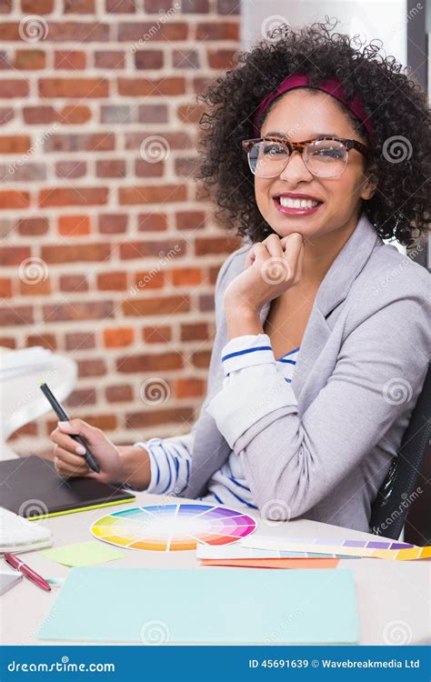 Editor De Fotos De Sexo Femenino Sonriente Usando El Digitizador En Oficina Imagen De Archivo