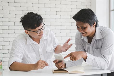 실업가의 그룹 상담 및 노트와 스마트 전화 회의 사무실에서 상호 작용 하는 계획 사업에 대 한 토론 가리키기에 대한 스톡 사진