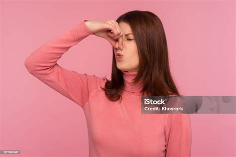 불쾌한 냄새를 느끼는 손가락으로 코를 잡고 불행 하게 혼란 브루넷 여자 혐오 방귀충격 25 29세에 대한 스톡 사진 및 기타
