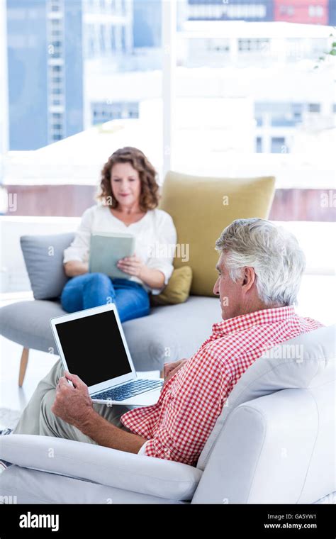 Mature Man Using Notebook While Sitting By Woman Stock Photo Alamy