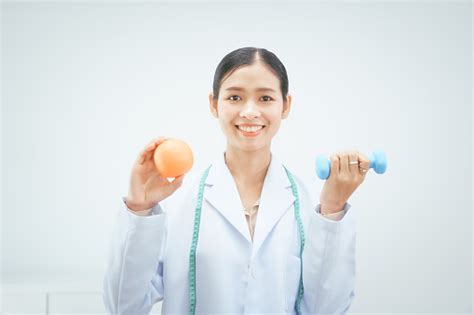 귀여운 여성 영양사 의사가 흰색 배경에 야채와 과일 바구니를 들고 건강한 식생활 균형 잡힌 식단 웰빙을 상징하며 전반적으로 영양가 있는 음식 선택을 촉진합니다 25 29세에