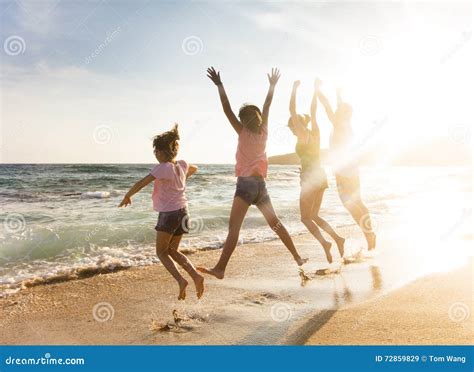 Glückliche Familie Auf Strand Bei Sonnenuntergang Springt Stockbild Bild von kindheit